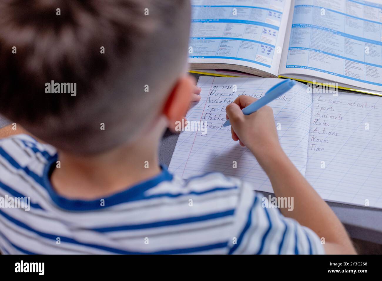 Schoolboy boy writes lessons in the kitchen Stock Photo - Alamy