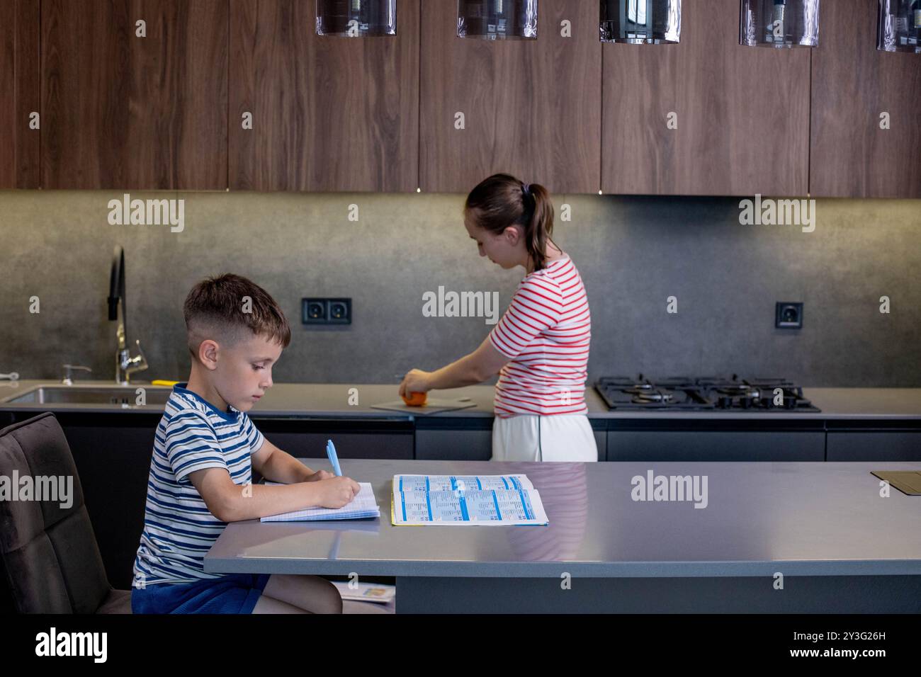 Mother Helping Son With Homework At Table Stock Photo - Alamy