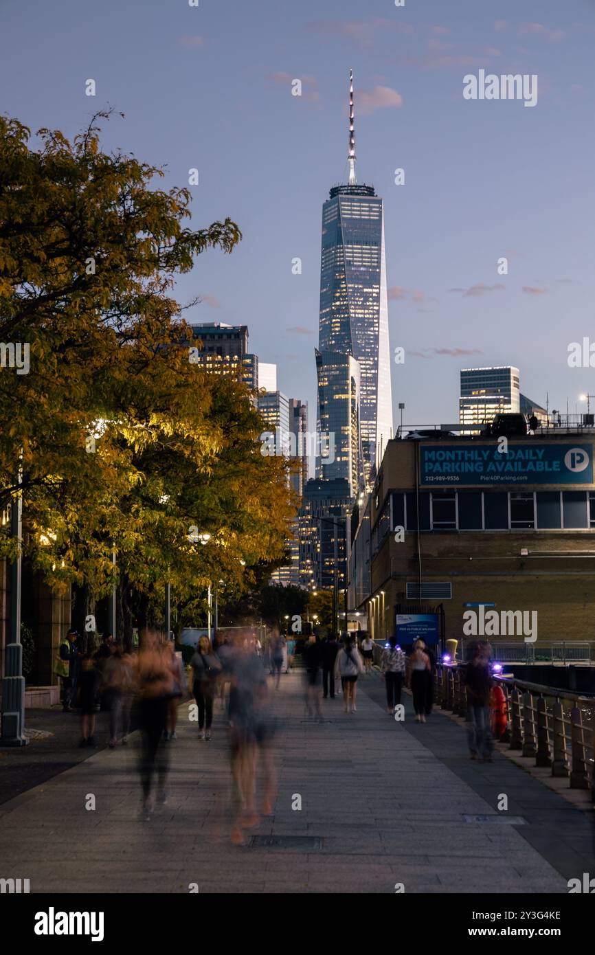 People walking on the west side highway with One World Trade Center in ...