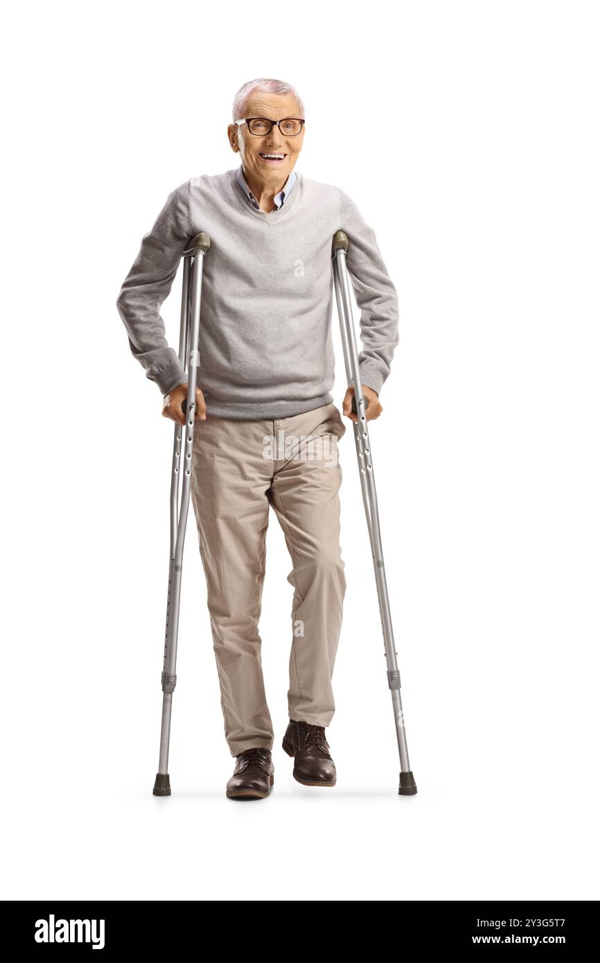 Elderly man with injured leg standing with crutches isolated on white ...