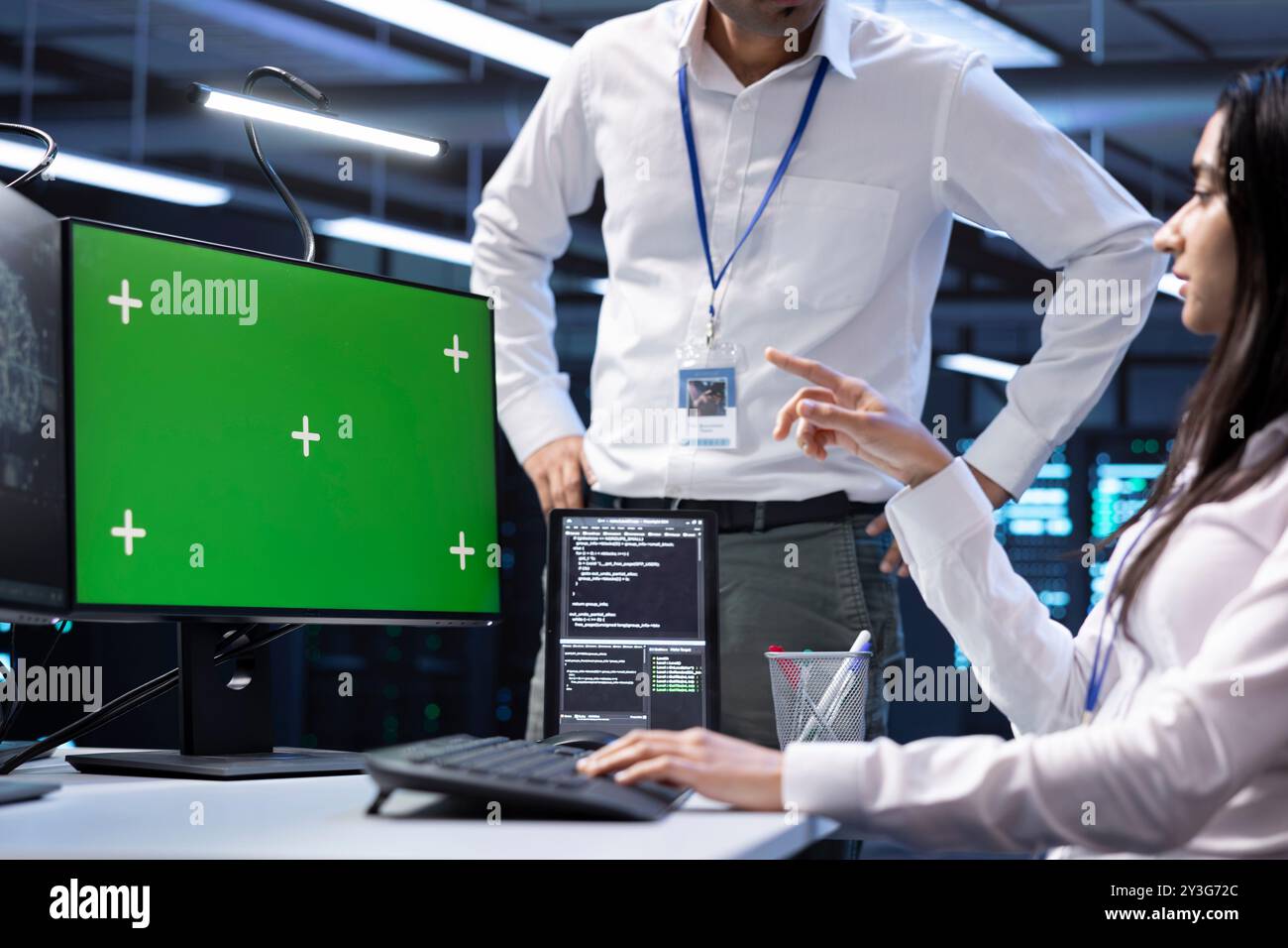 Software developers doing checkup on green screen computer in server room used for artificial ...