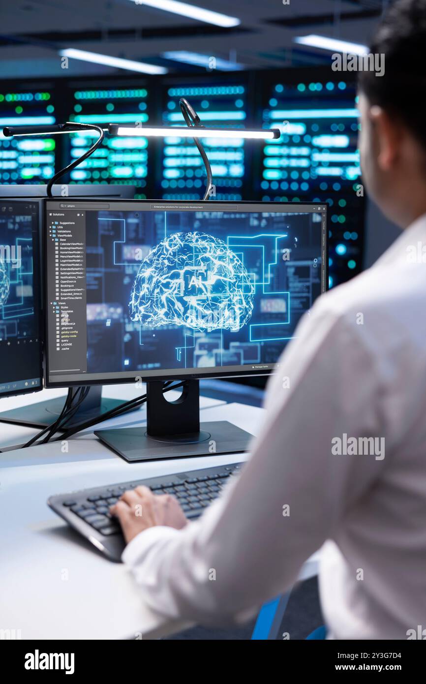 System administrator working in data center providing computing resources needed for artificial ...