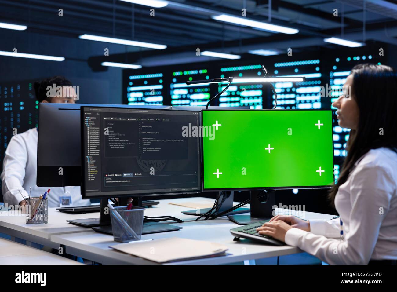 Specialists using green screen PC to check server clusters configuration settings. Engineers ...