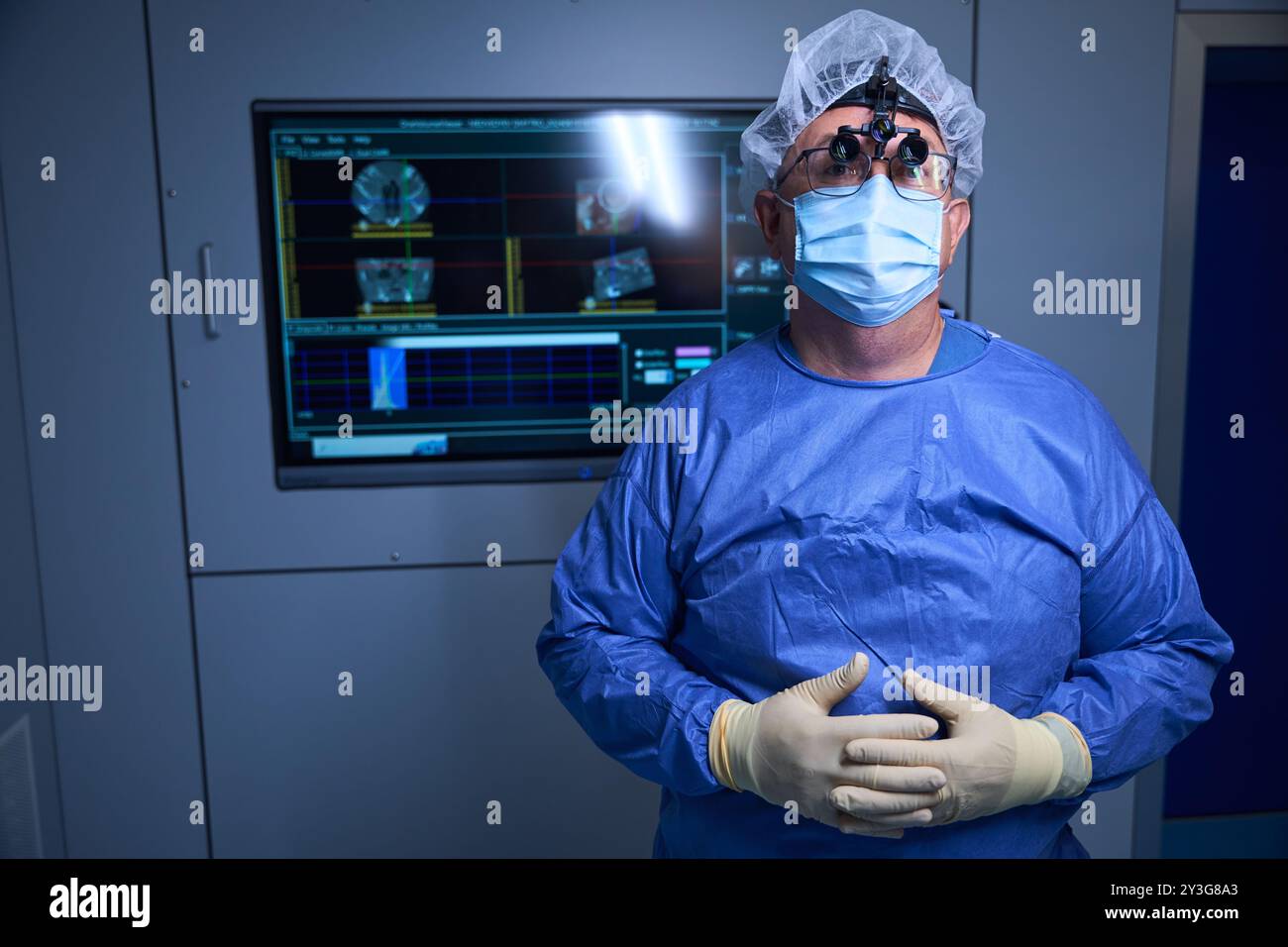 Surgeon standing before monitor in operating room Stock Photo - Alamy