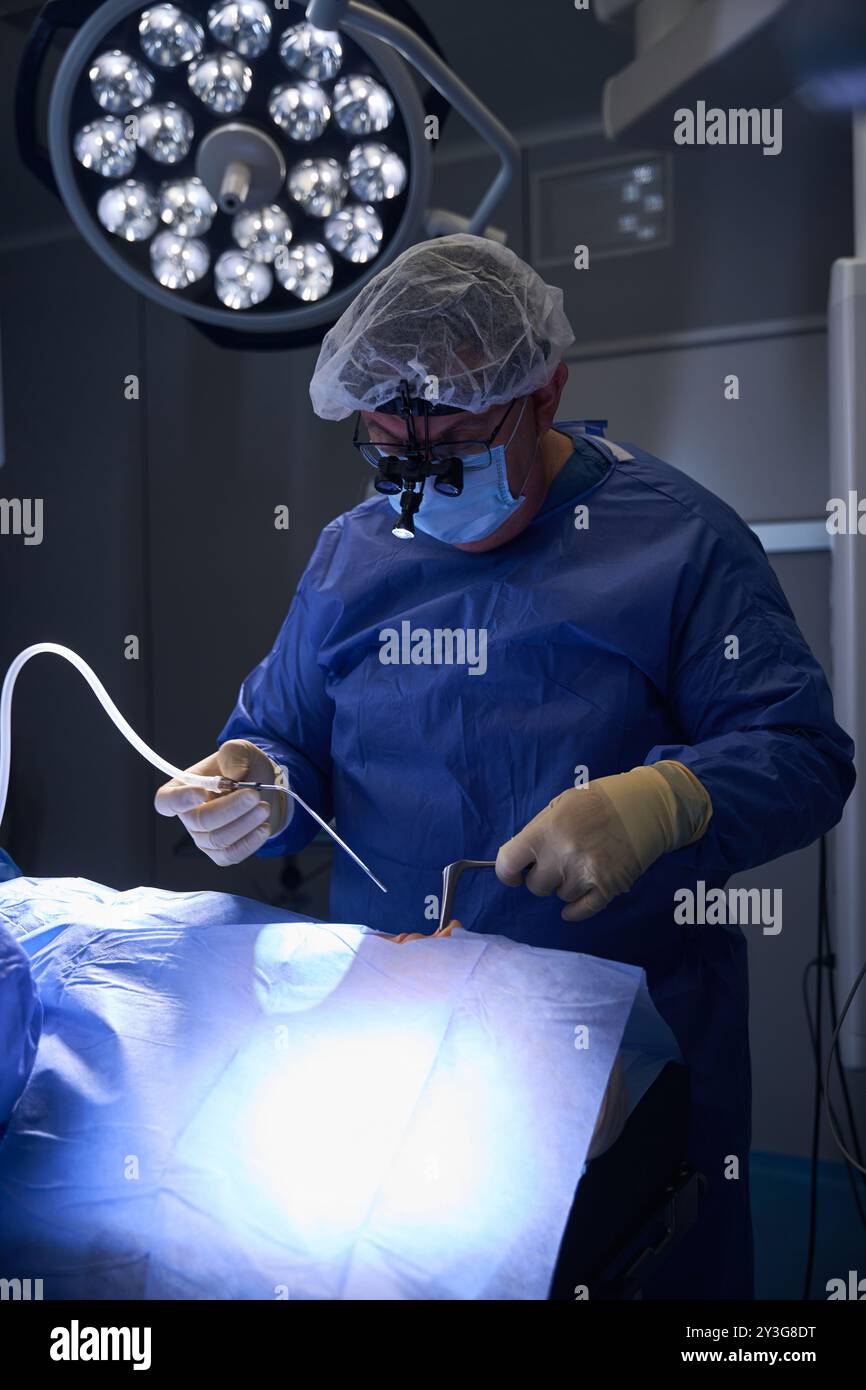 Surgeon conducting surgery under bright operating lights Stock Photo ...