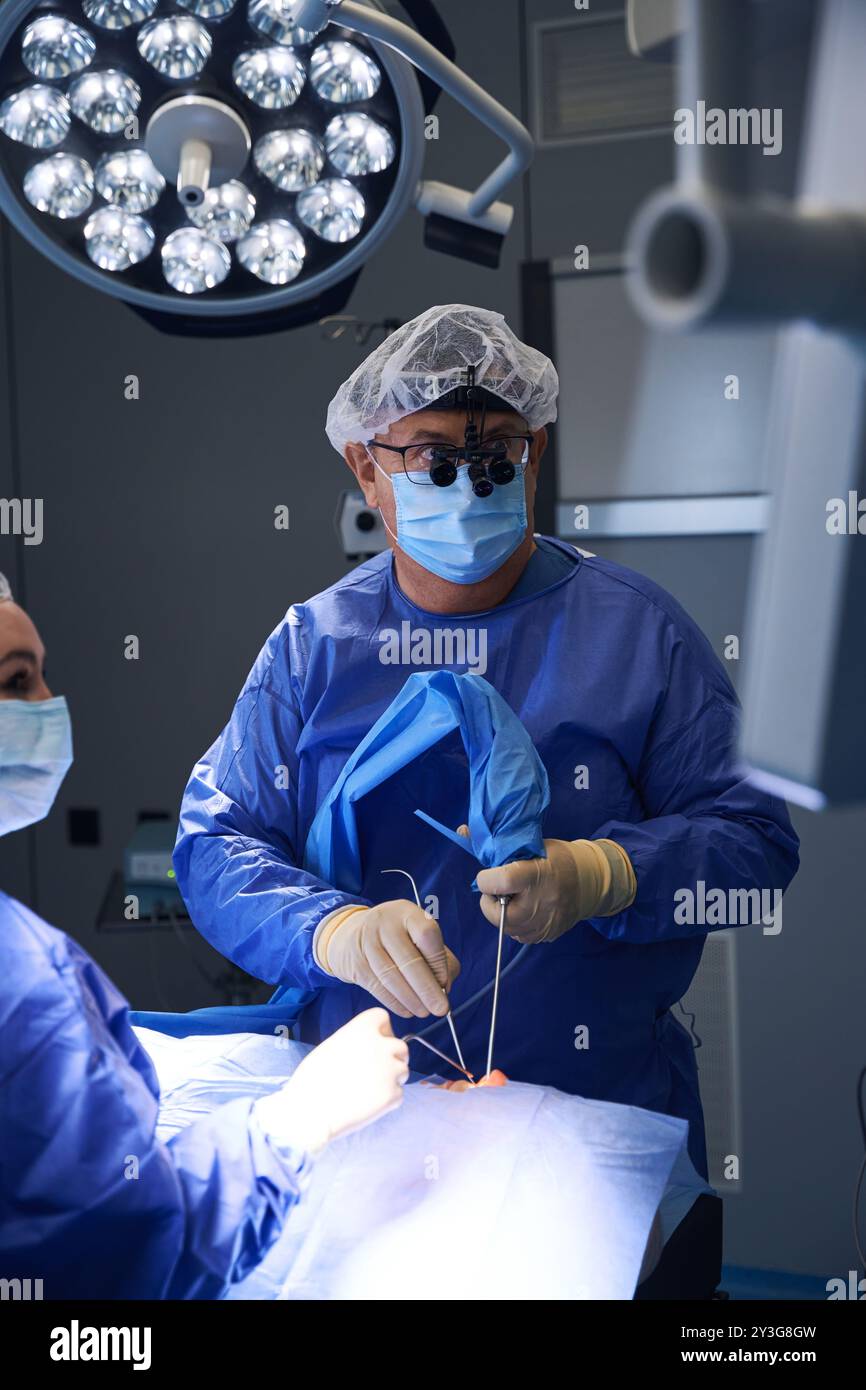 Surgeon examining patient data on monitor during surgery Stock Photo ...