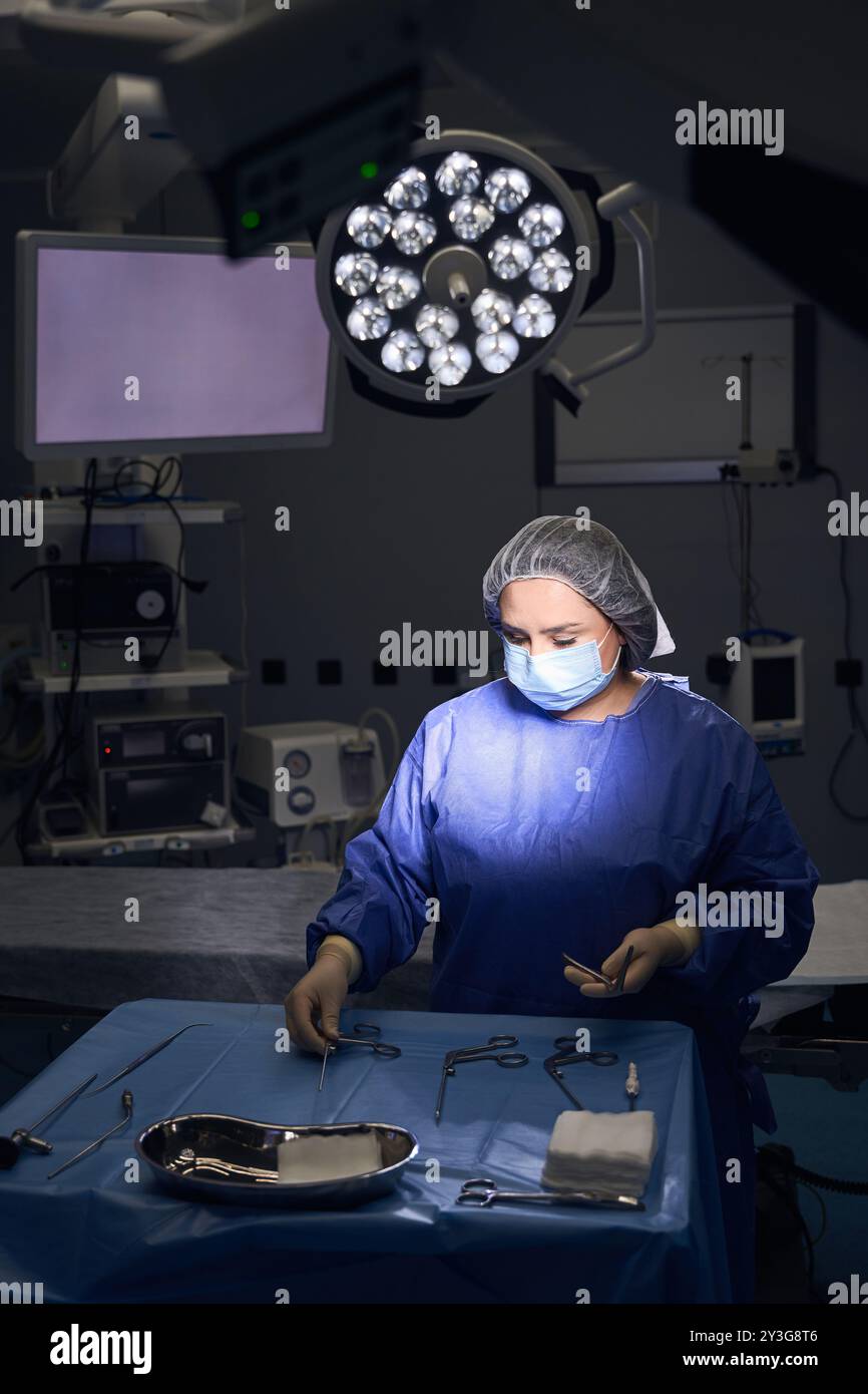 Female surgeon assistant preparing instruments on surgical table Stock ...
