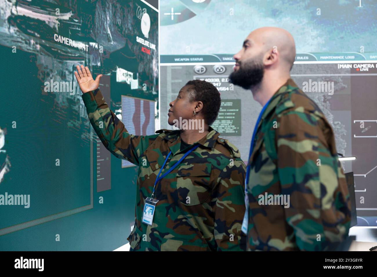 Man And Woman Monitoring Real Time Information On A Big Screen In Command Center Army Base