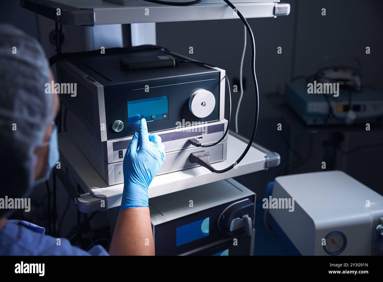 Medical staff adjusting settings on surgical equipment Stock Photo - Alamy