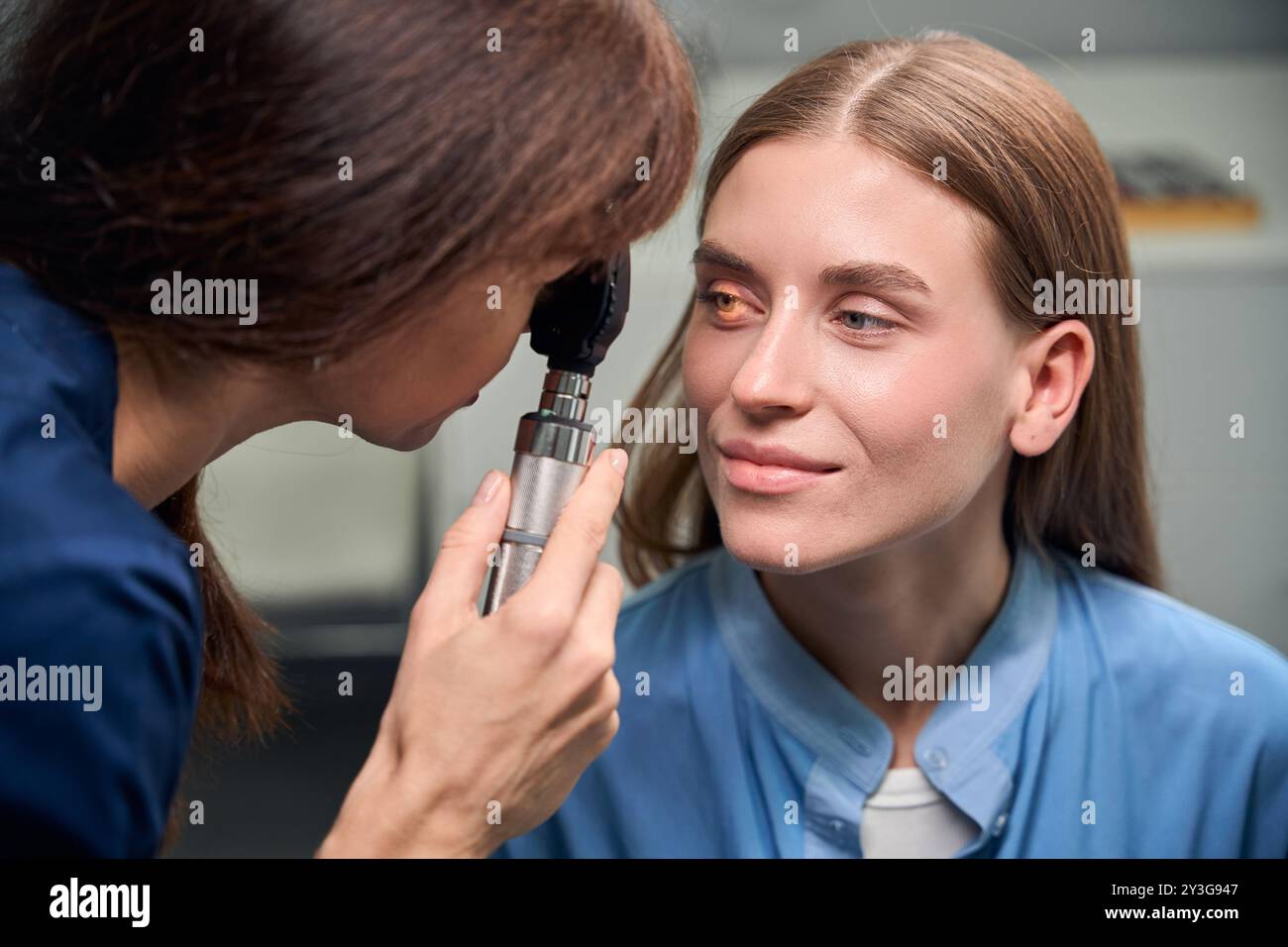 Caucasian optometrist examining patients eyes with ophthalmoscope Stock ...