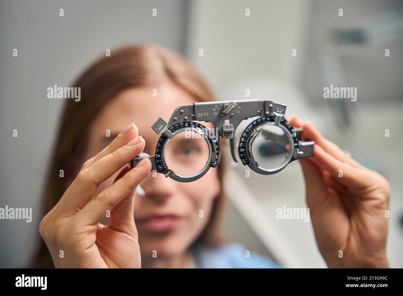 Female patient holding trial frame for vision testing Stock Photo - Alamy