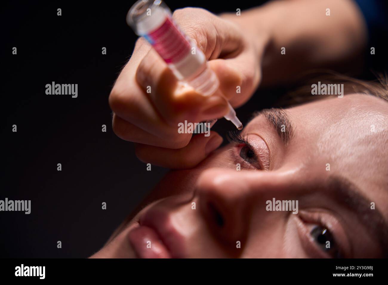 Eye drops administered into female patient eye Stock Photo - Alamy
