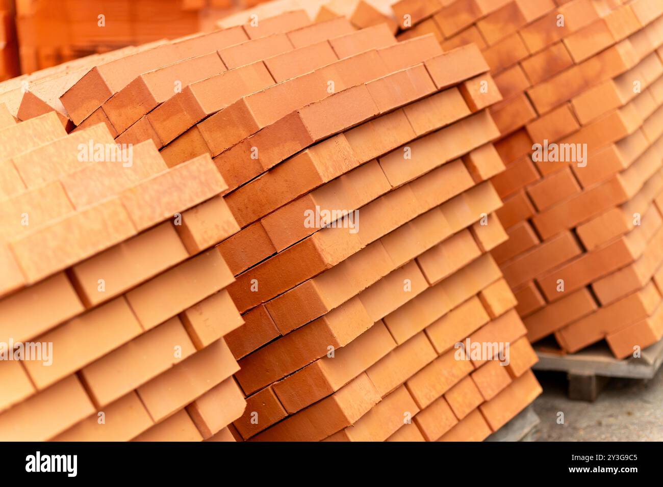 Stacks of new, red ceramic brick stacked on wooden pallets. Lots of new ...
