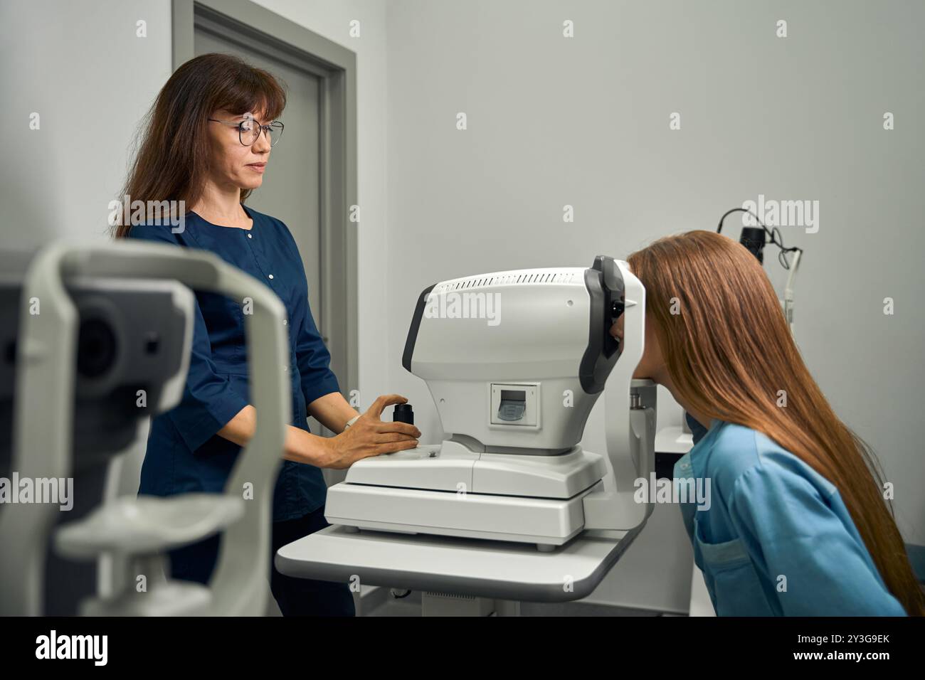Female patient undergoing non-invasive eye exam procedure Stock Photo ...