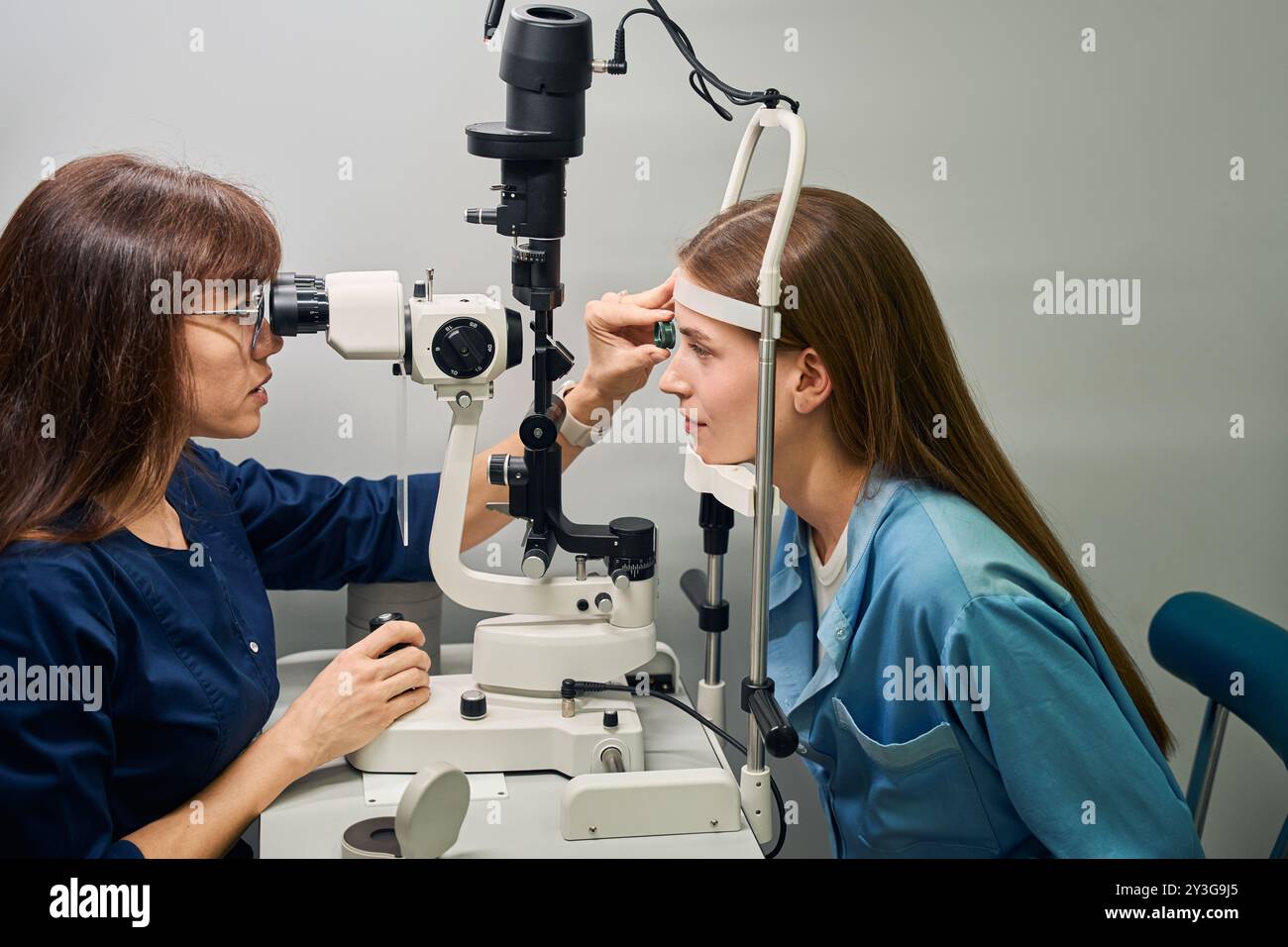 Optometrist performing eye examination on young patient Stock Photo - Alamy