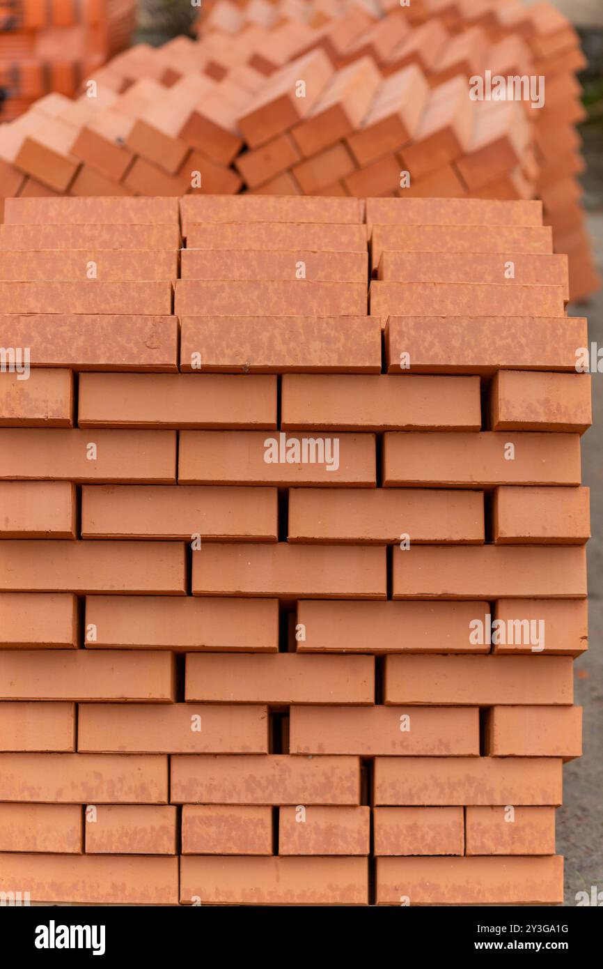 Stacks of new, red ceramic brick stacked on wooden pallets. Lots of new ...
