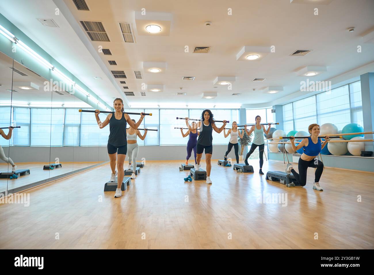 Young women perform a set of exercises with gymnastic sticks Stock ...