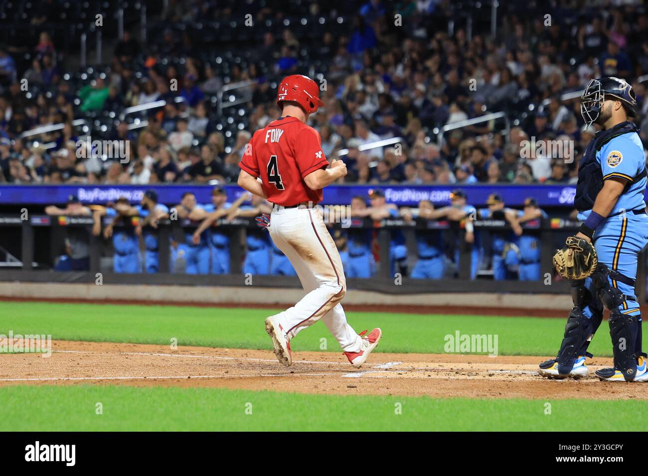 New York's Bravest Brian Luebcke #4 is congratulated after scoring during the baseball game ...