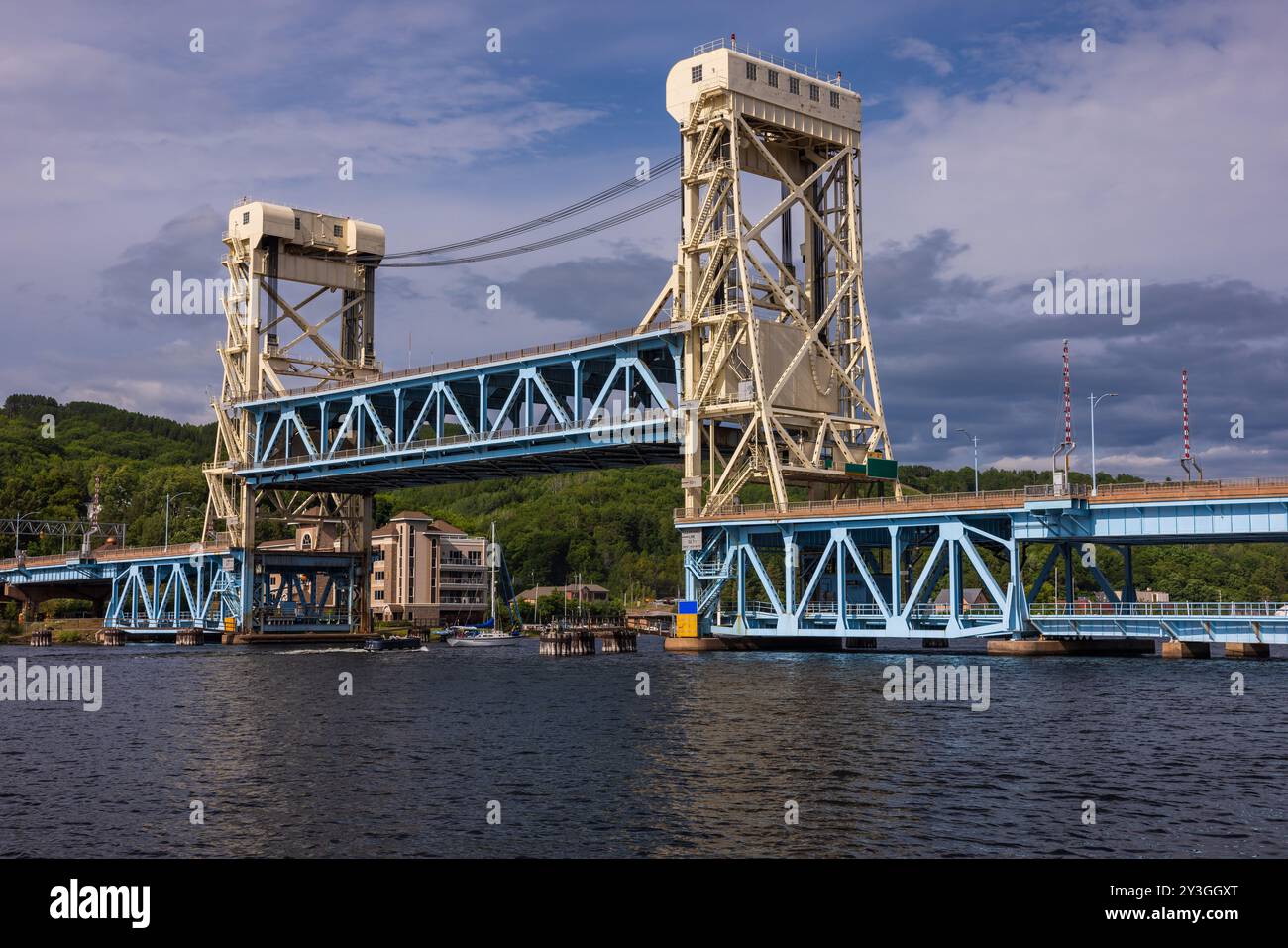 A double deck lift bridge in the raised position with boats passing ...