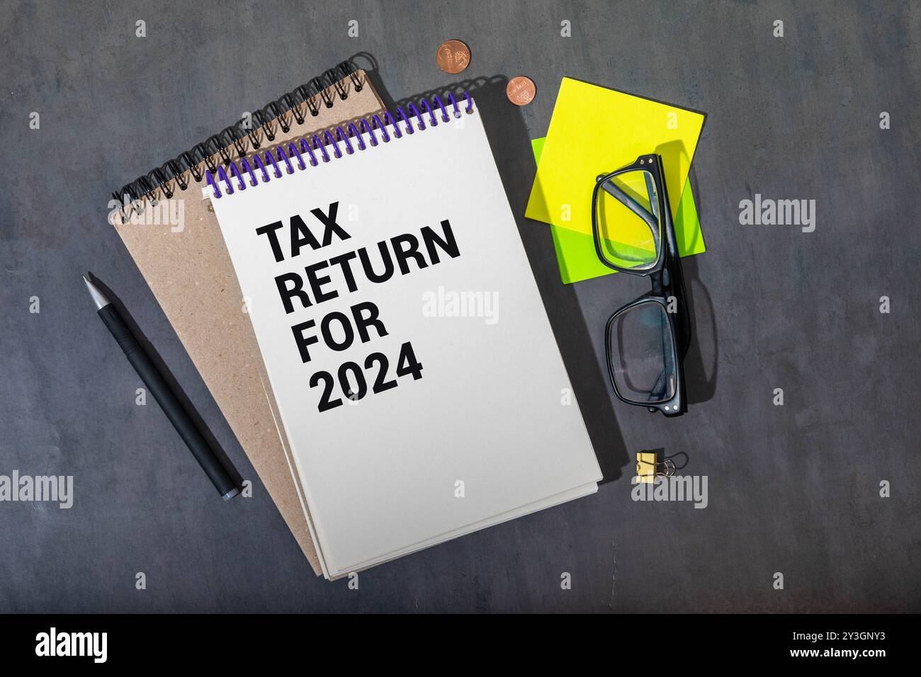 White paper sheet with text INCOME TAX RETURN 2024 on the black laptop ...