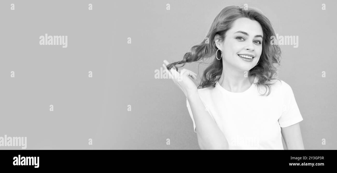 glad redhead girl with curly hair on blue background. Woman isolated ...