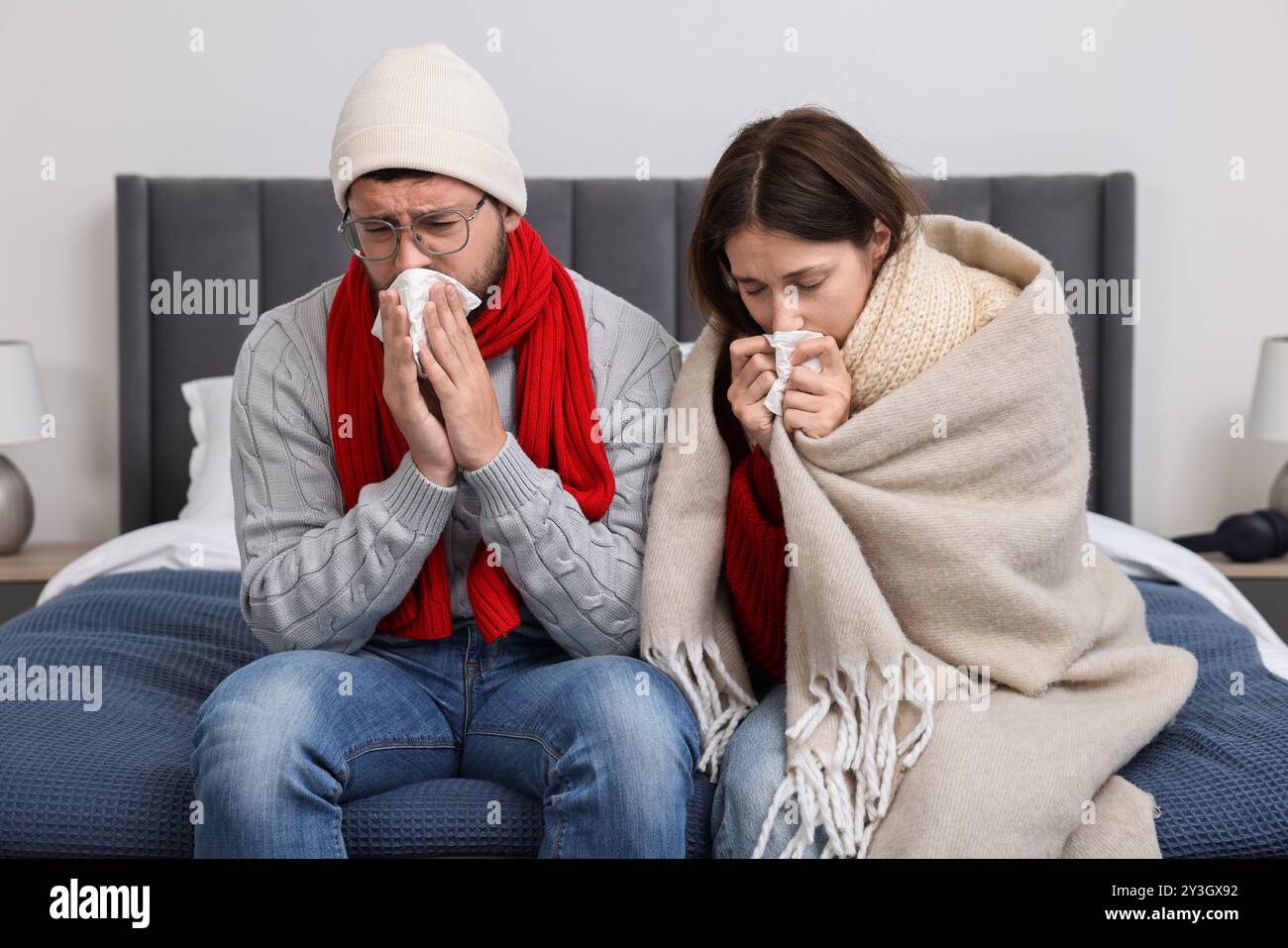 Cold symptom. Couple suffering from fever on bed at home Stock Photo ...