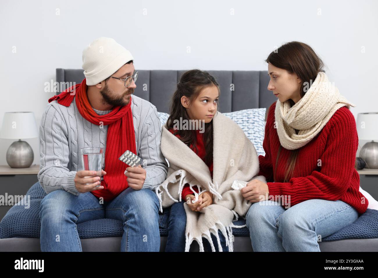 Cold symptom. Family suffering from fever on bed at home Stock Photo ...
