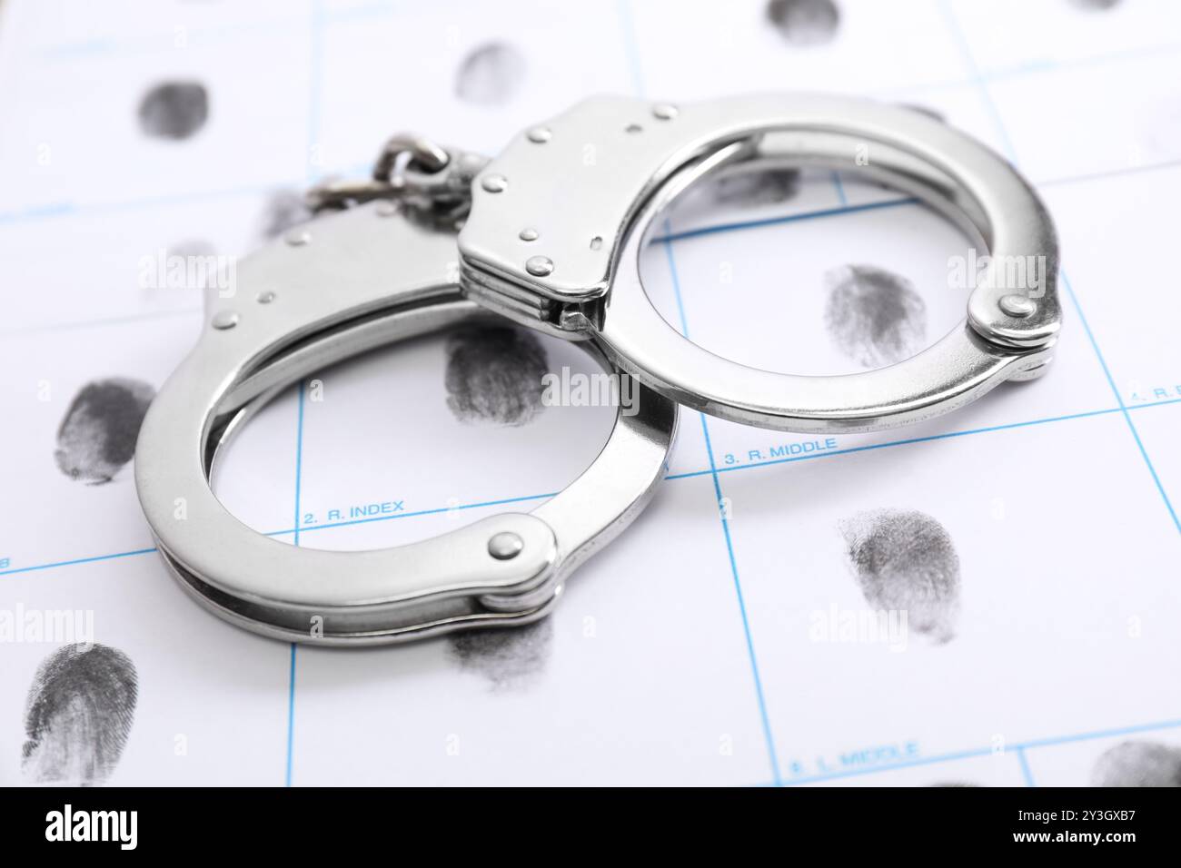 Human fingerprints and handcuffs on paper, closeup. Criminal conviction ...