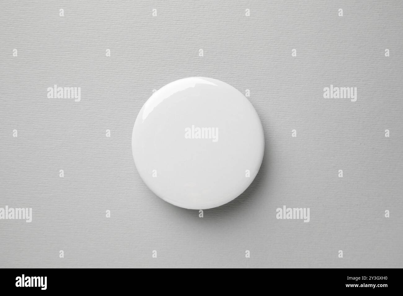 Blank white button badge on grey background, top view. Mockup for ...
