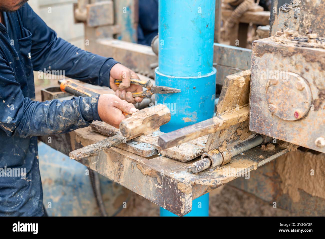 Worker hit nails pvc pipe connecting with hammer in artesian well Stock ...