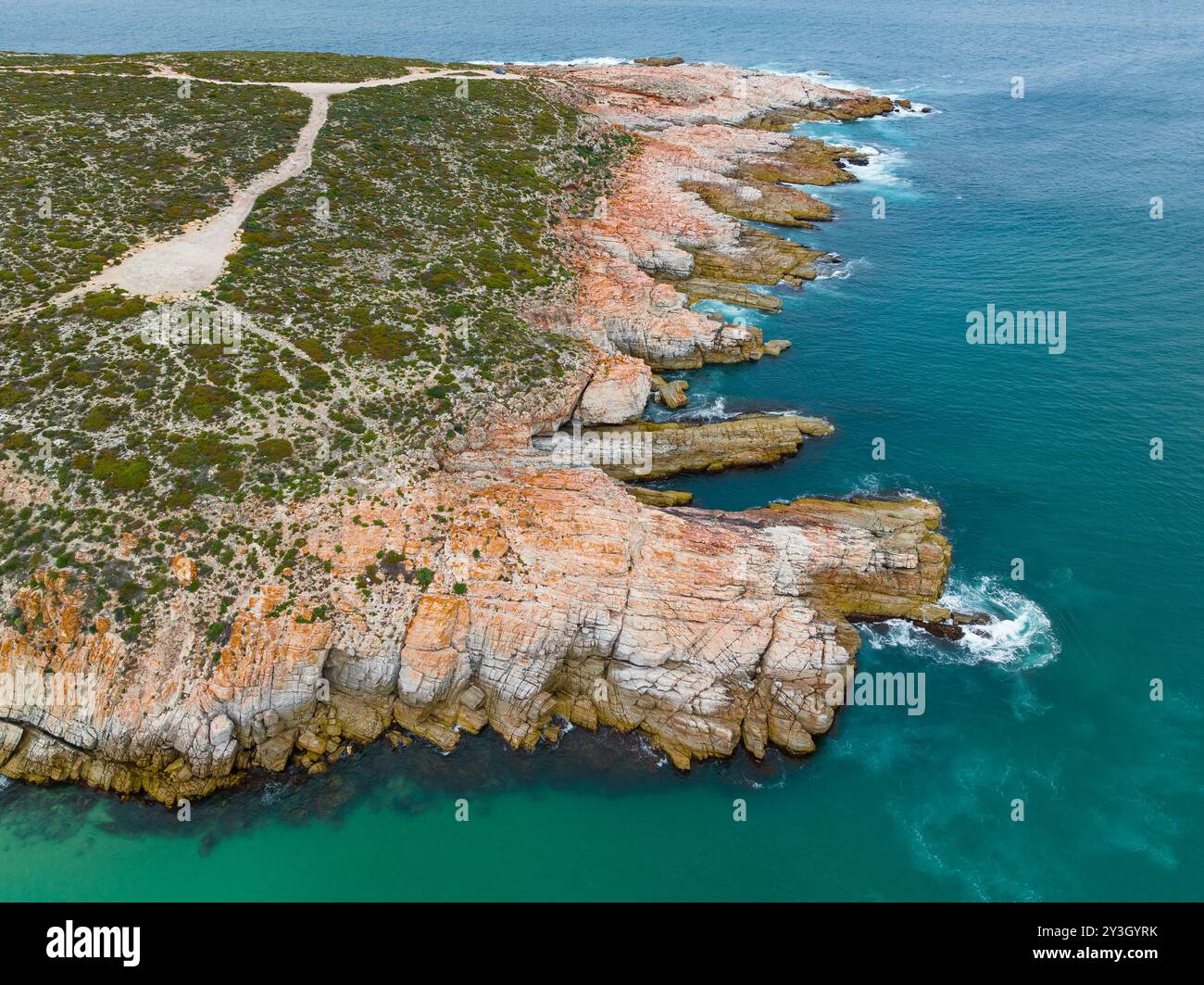 Aerial view of a coastal headland with lichen covered rocks at Coles ...