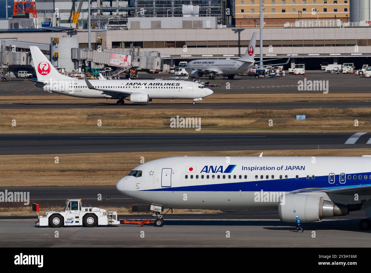 A Boeing 767-381(ER) with All Nippon Airways (ANA) is towed by a tug in front of an JAL Boeing ...