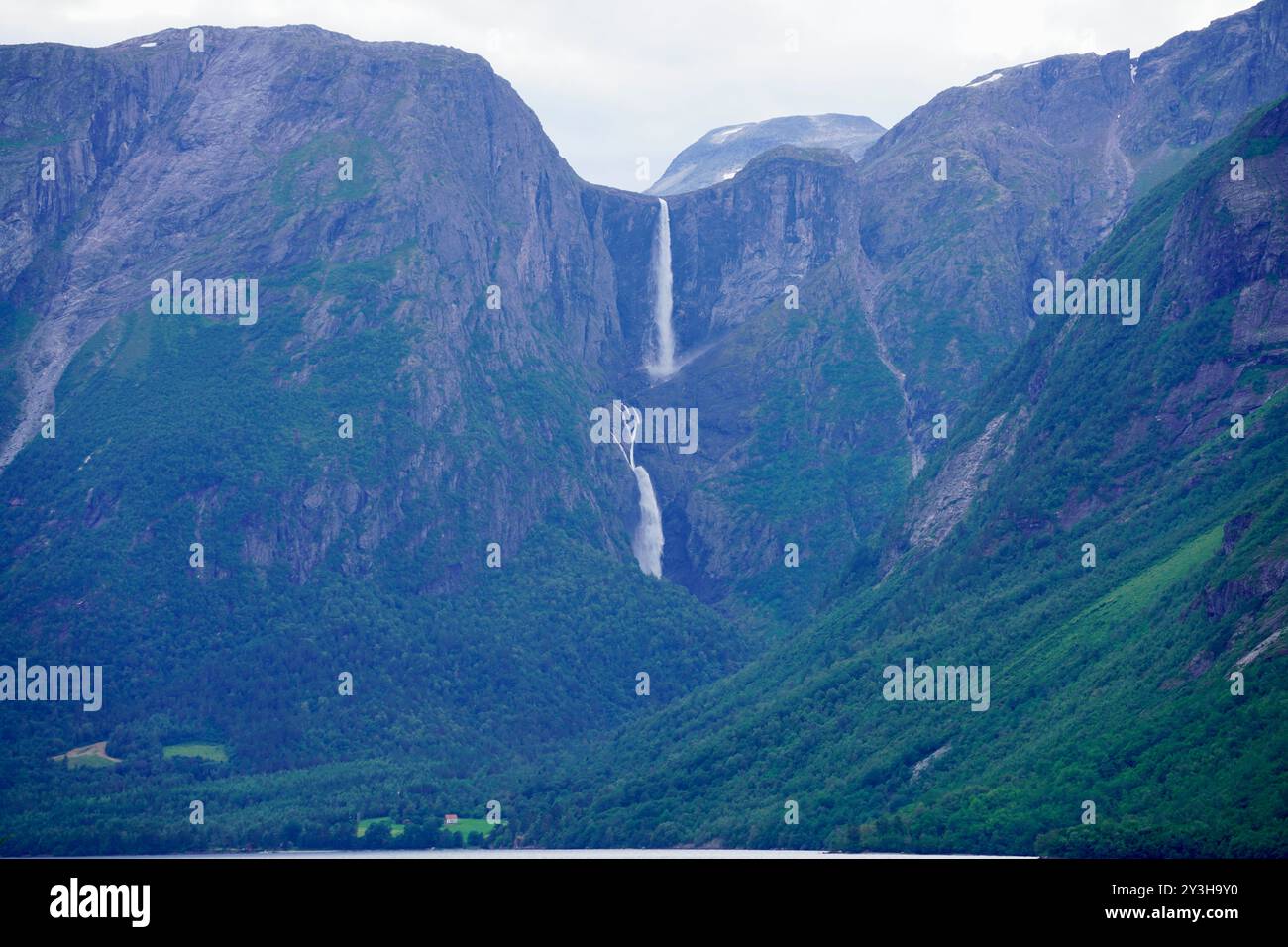 A stunning view of a tall waterfall cascading down a mountain in a lush ...