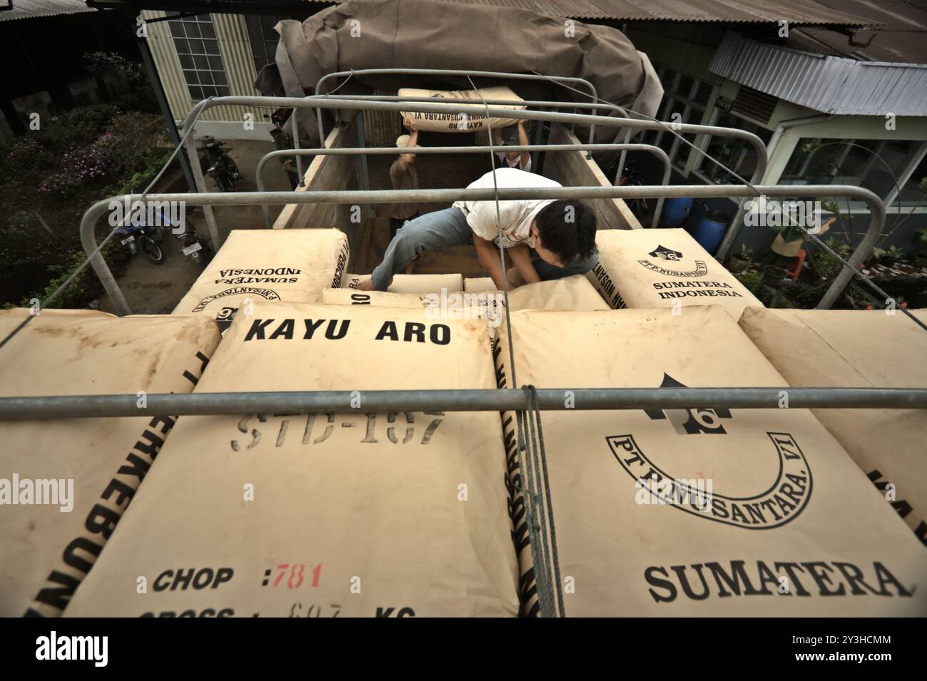 Workers loading tea sacks onto a truck at Kayu Aro tea factory in ...