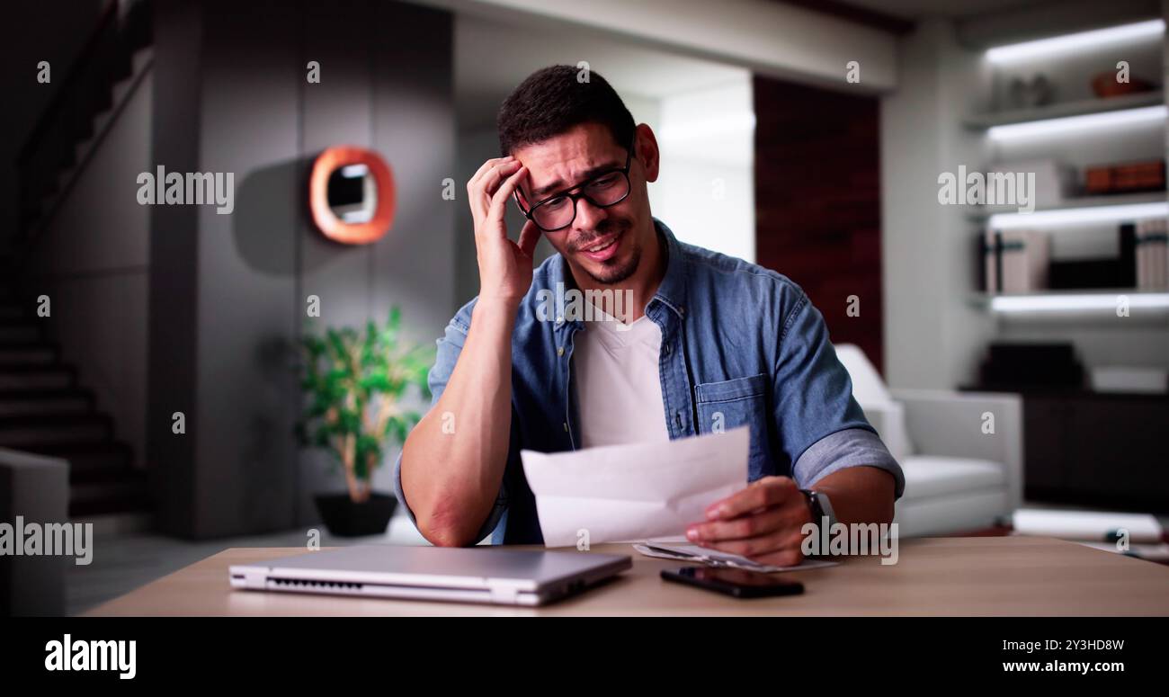 Sad Man Reading Paper Invoice With Stress Stock Photo - Alamy