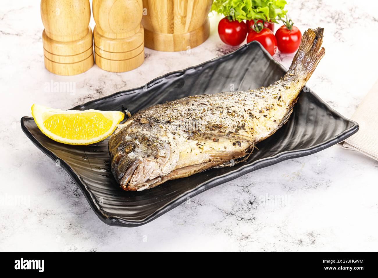 Baked Dorado fish served lemon slice Stock Photo - Alamy