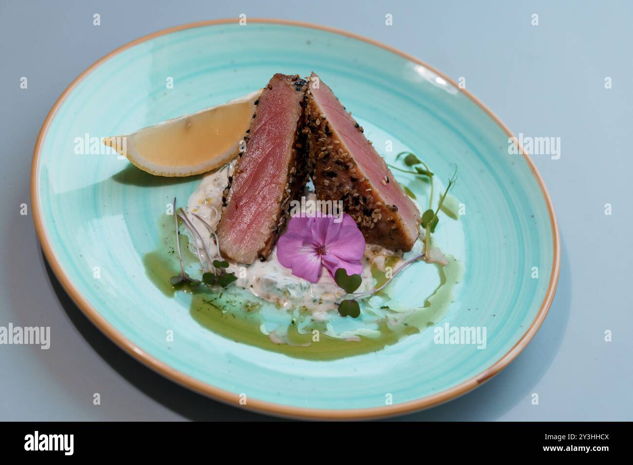 Gourmet Seared Tuna with Decorative Edible Flower and Lemon Wedge on ...