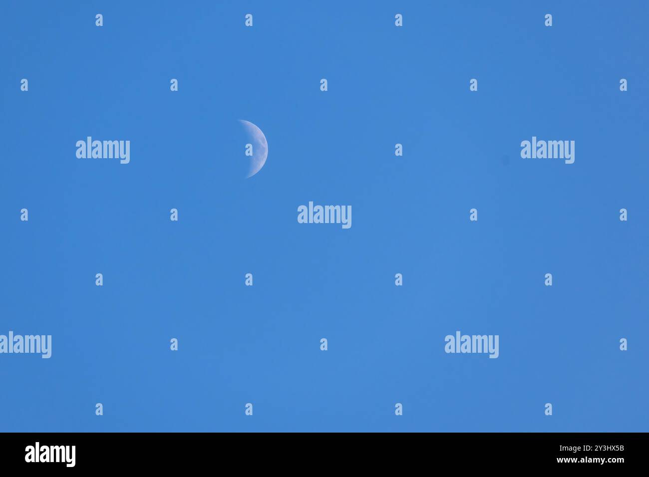 Beautiful half-moon at the late afternoon sky. A crescent moon in the ...