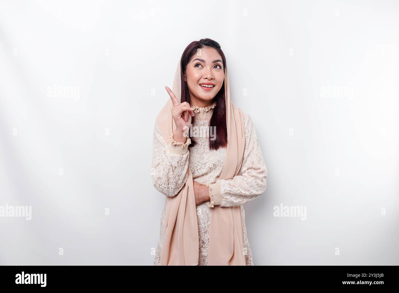 Starving Asian Muslim woman wearing a headscarf, pointing up at the ...