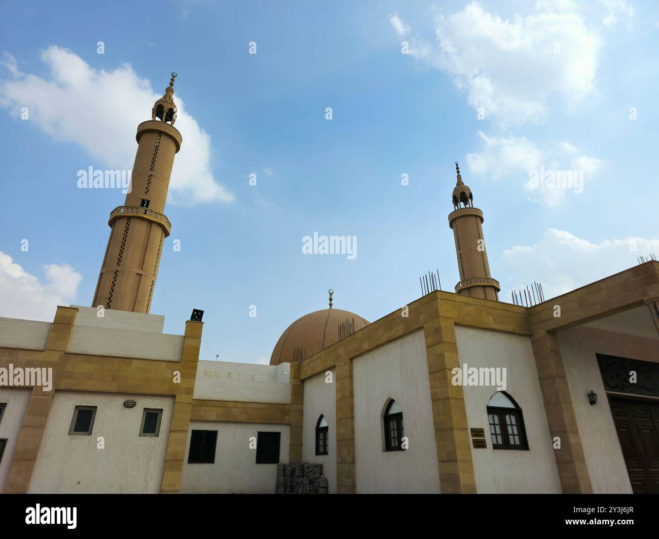 The Exterior of a grand large mosque in Cairo against blue cloudy sky ...