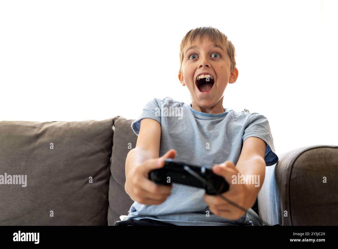 Child playing video game, excited expression Stock Photo - Alamy
