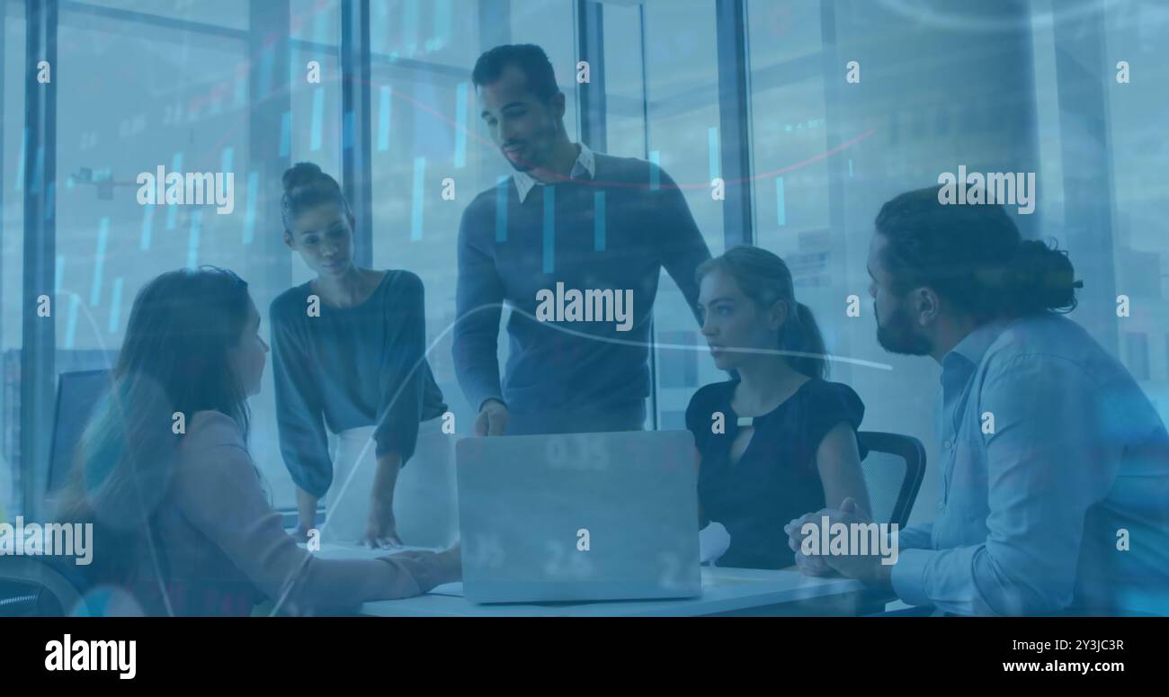 Business team collaborating at desk with financial data image over them ...