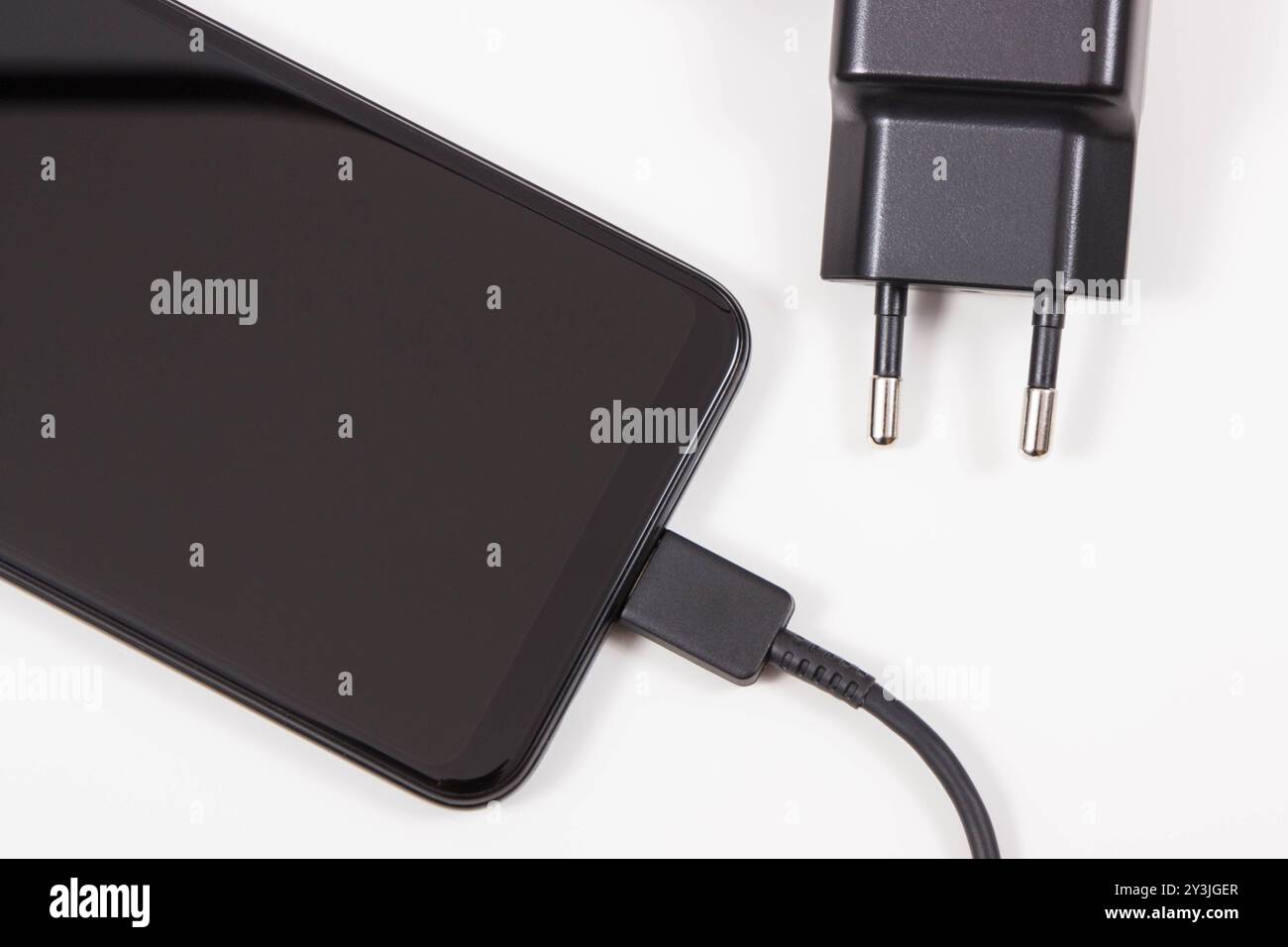 Smartphone with connected plug of charger. Telephone charging. White ...