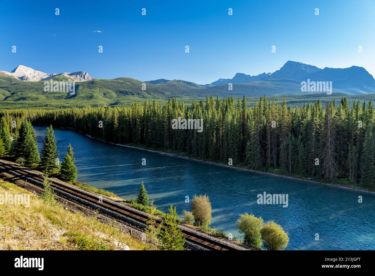 Bow River flows through forest and railway track. Storm Mountain in the ...