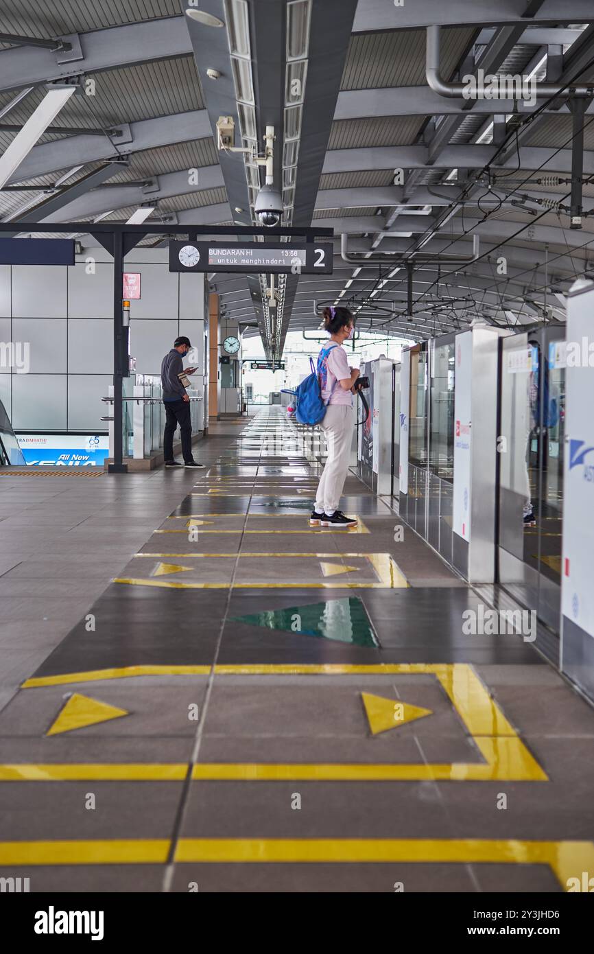 Passenger, traveler, tourist waiting for MRT Jakarta train at station ...