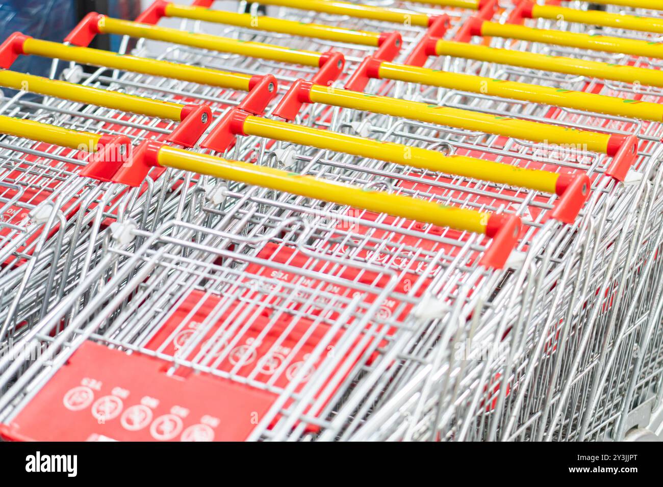 A close-up view of multiple shopping carts lined up in a store. The ...