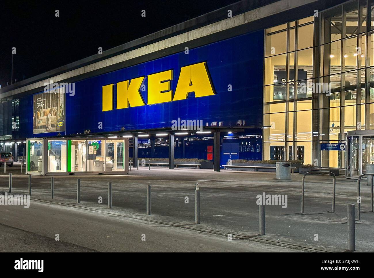 Nighttime view of an IKEA store with bright yellow signage on a blue ...