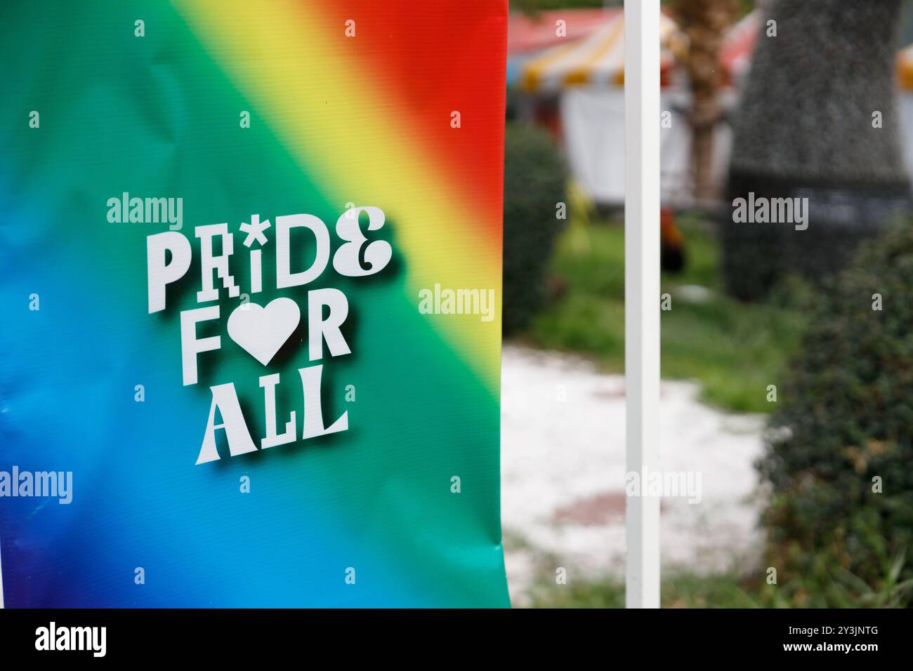 A white banner with the words "Pride for All" in colorful rainbow ...