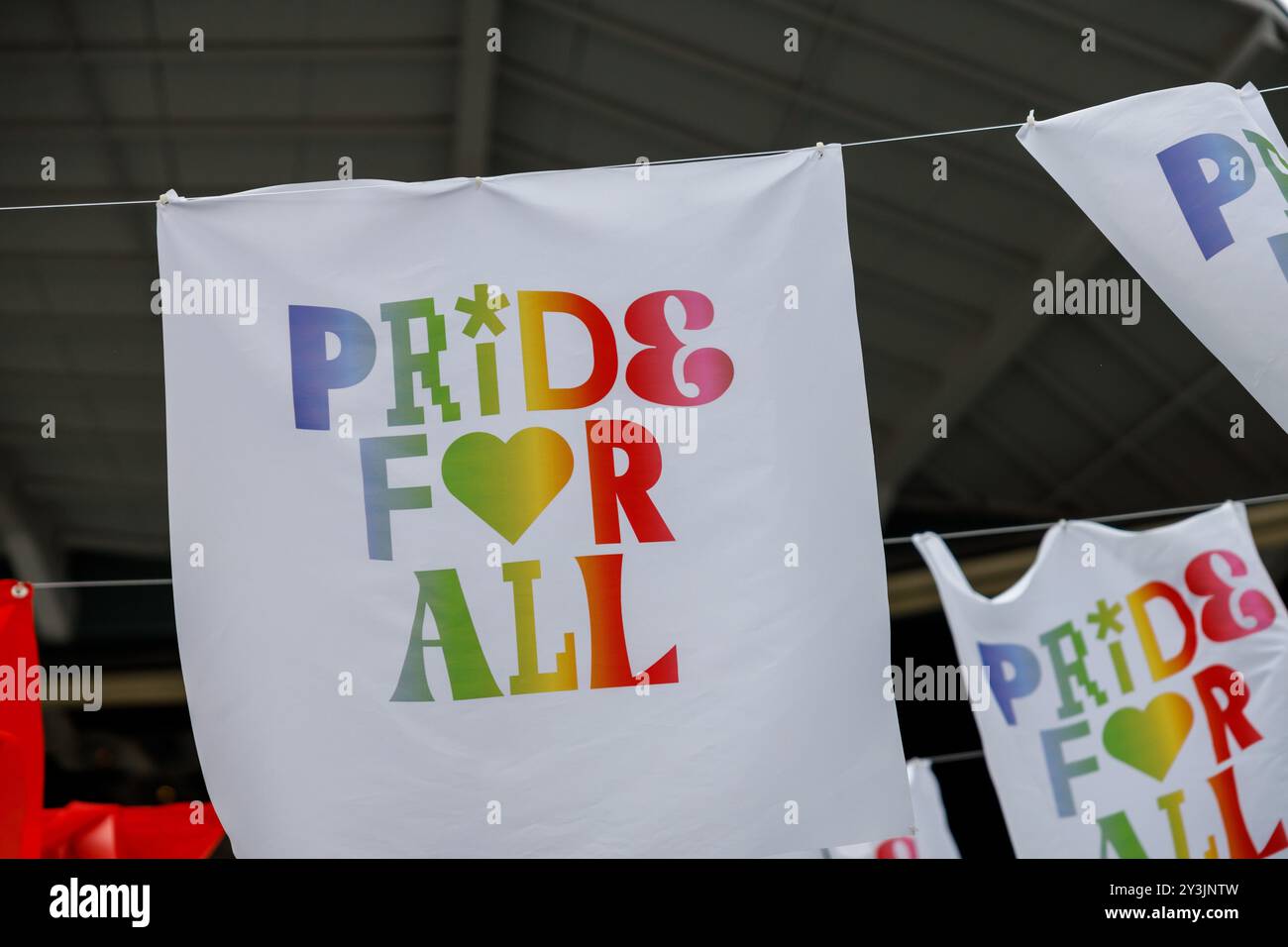 A white banner with the words "Pride for All" in colorful rainbow ...