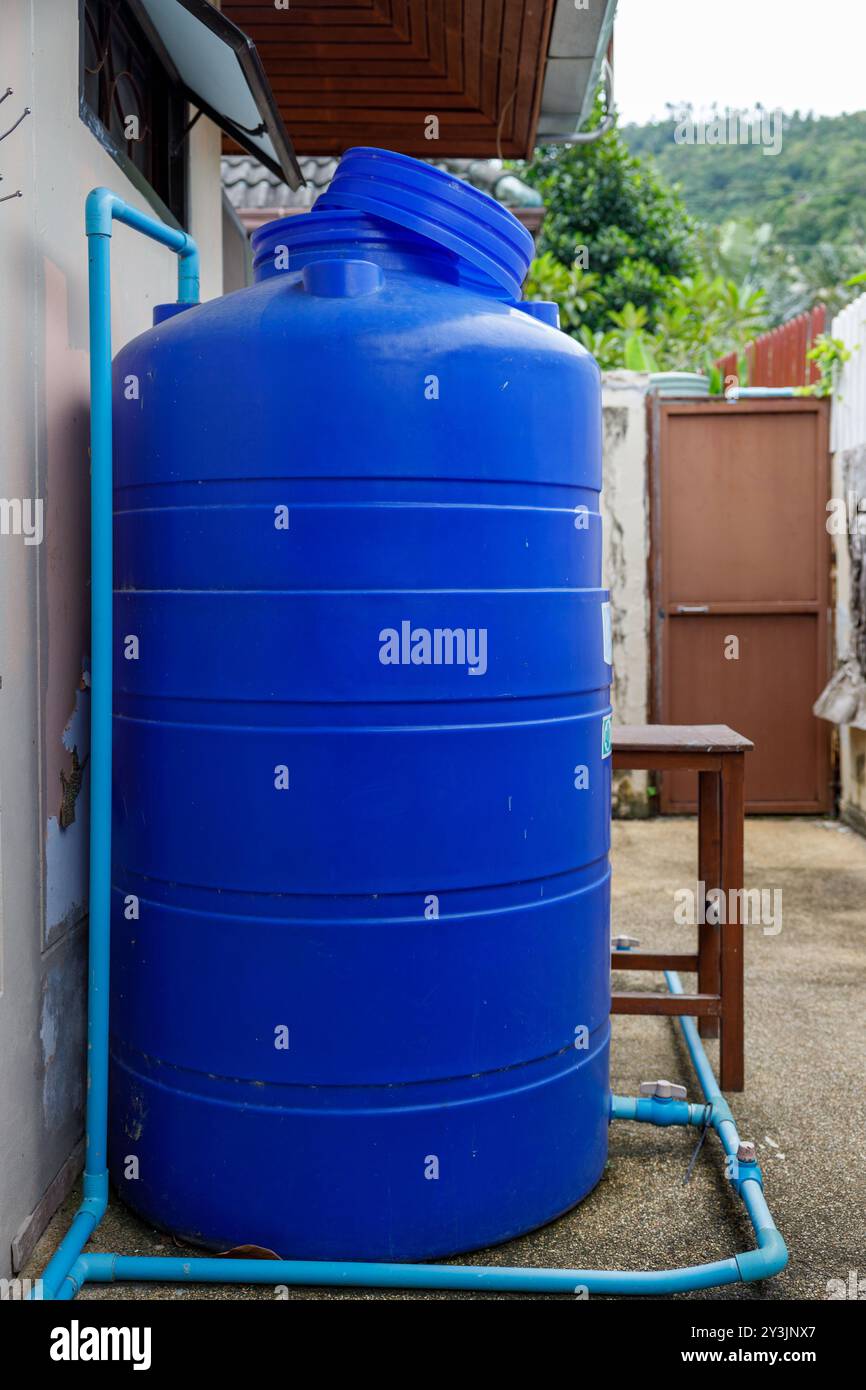 A large blue water storage tank commonly used in Thailand for ...
